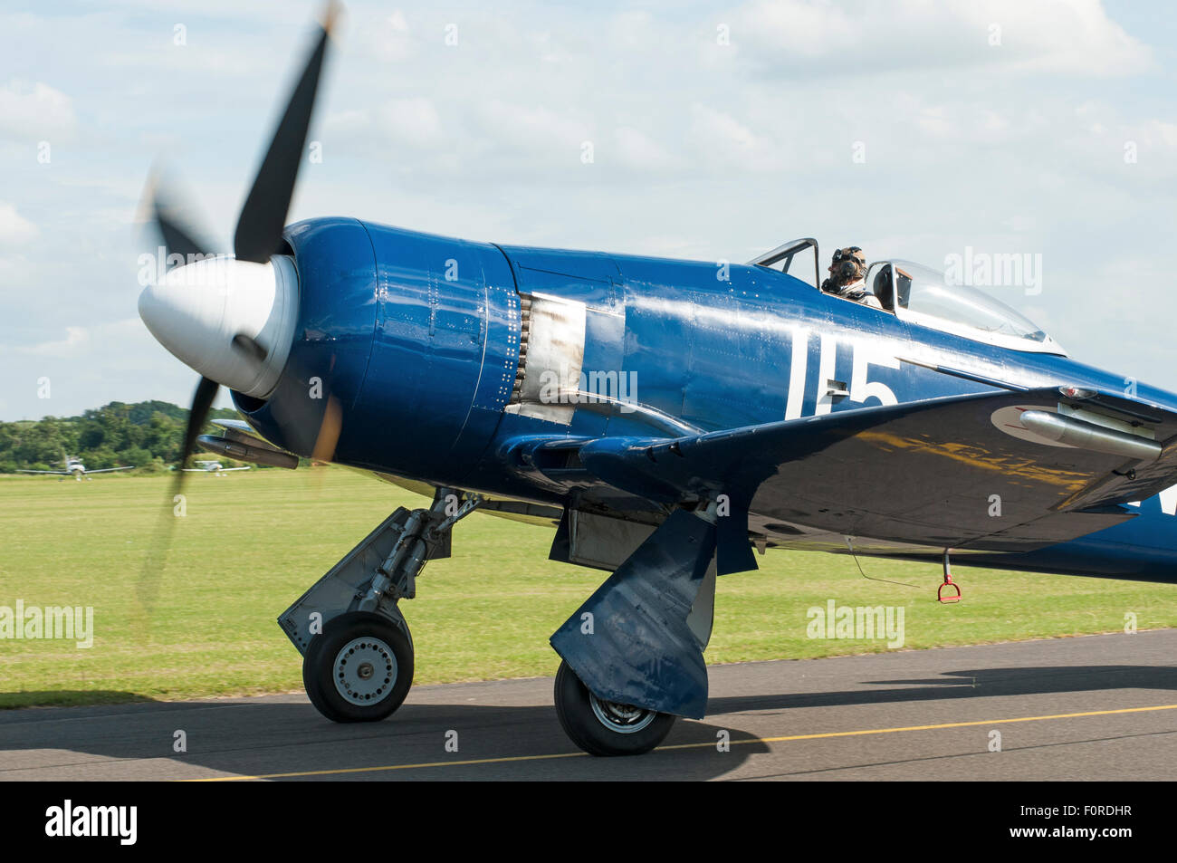 Closeup image of a blue vintage/classic British fighter aircraft taxing ...