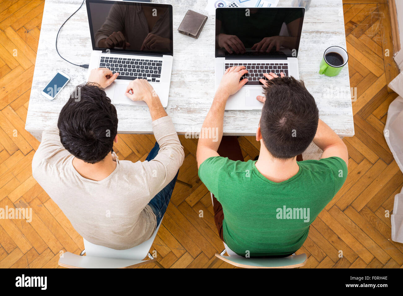 Two workmates teaming up and working together Stock Photo - Alamy