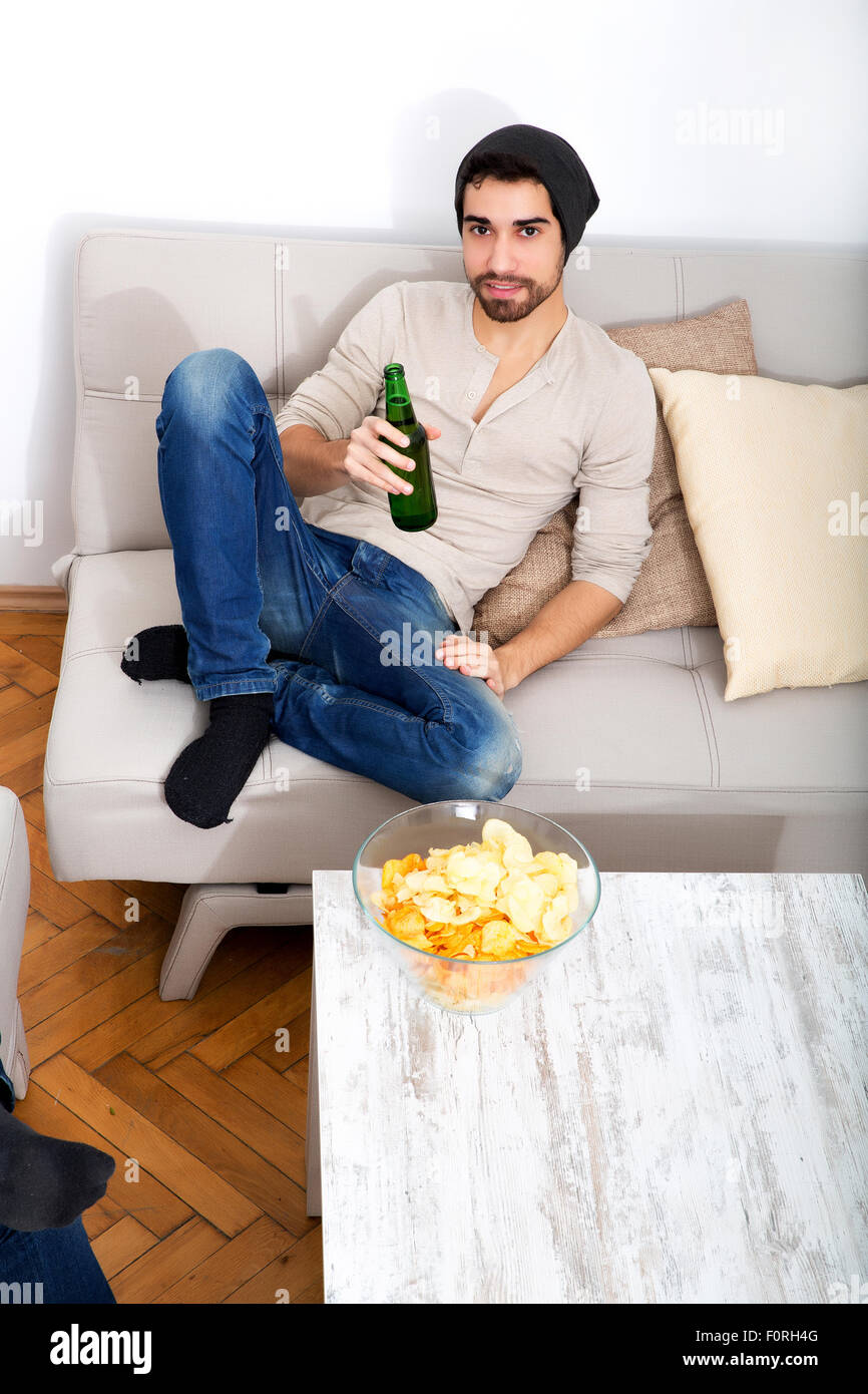 Portrait of a young man drinking beer at home Stock Photo - Alamy