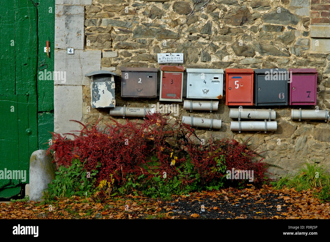 colored mailboxes on stonewall Stock Photo - Alamy