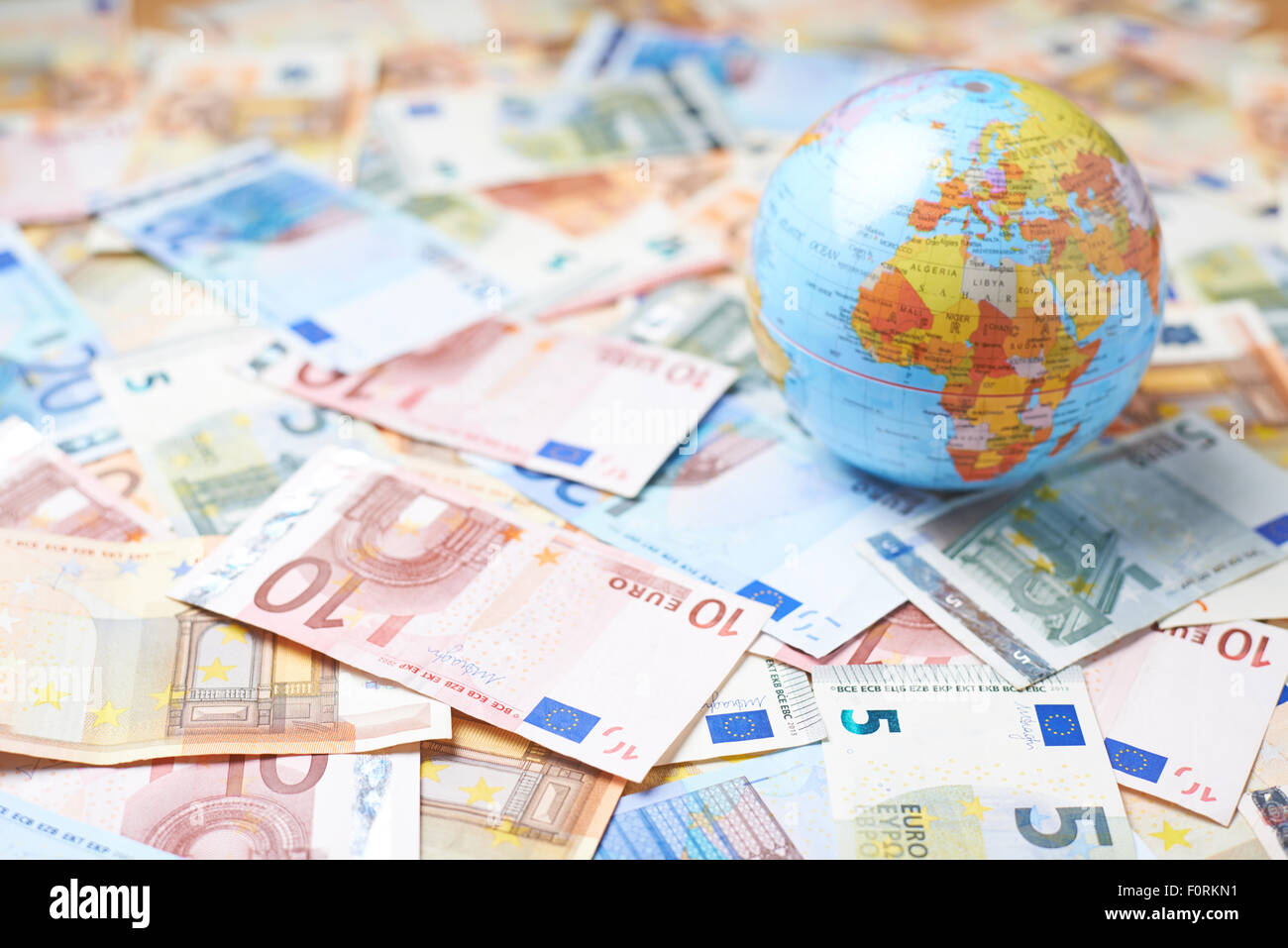 Earth globe over the pile of money Stock Photo - Alamy