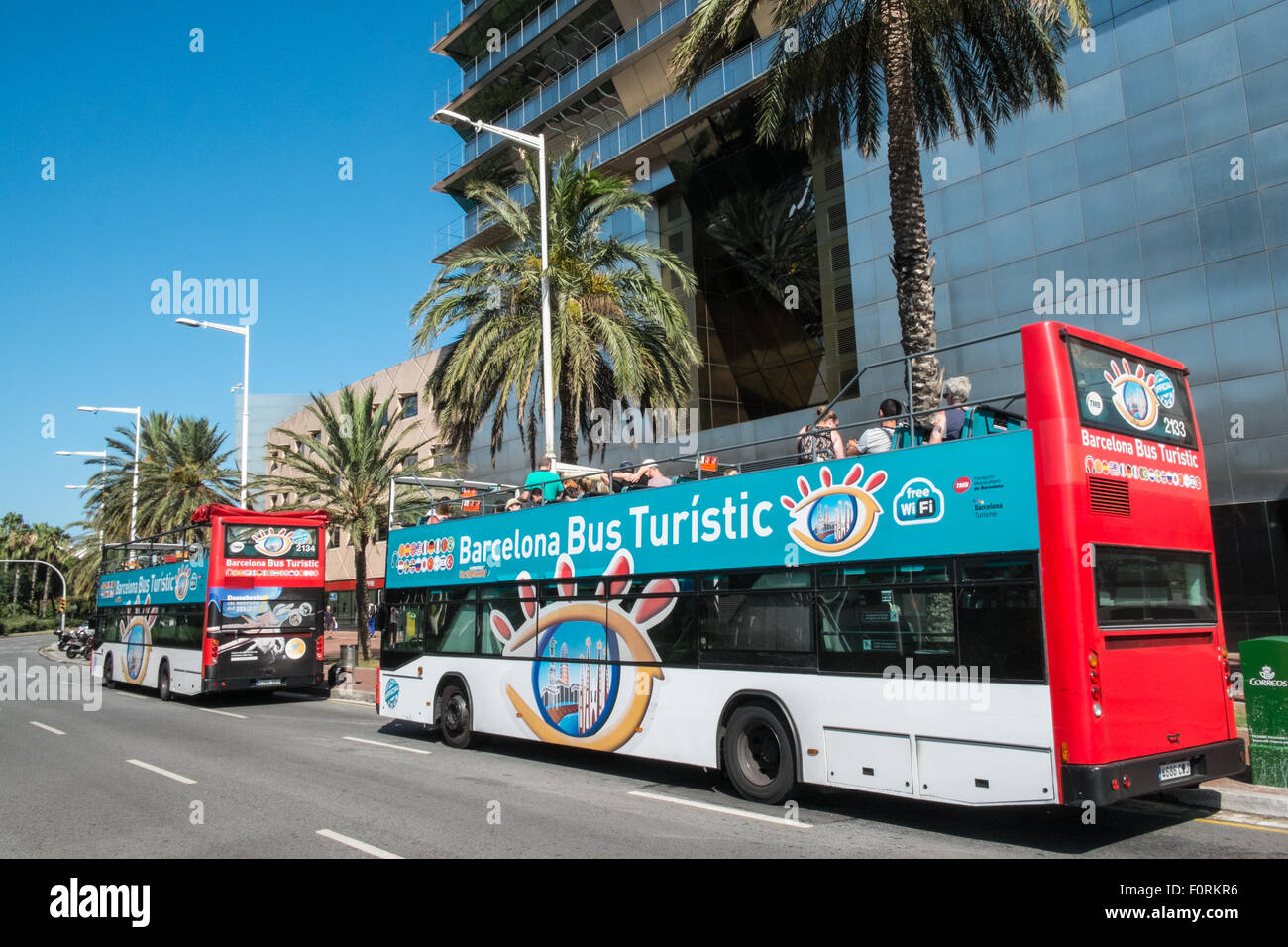 Two hop-on,hop-off tour buses at base of Mapre Tower one of the twin ...