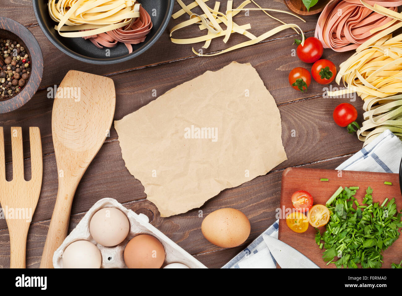 Pasta cooking ingredients and utensils on wooden table. Top view with ...