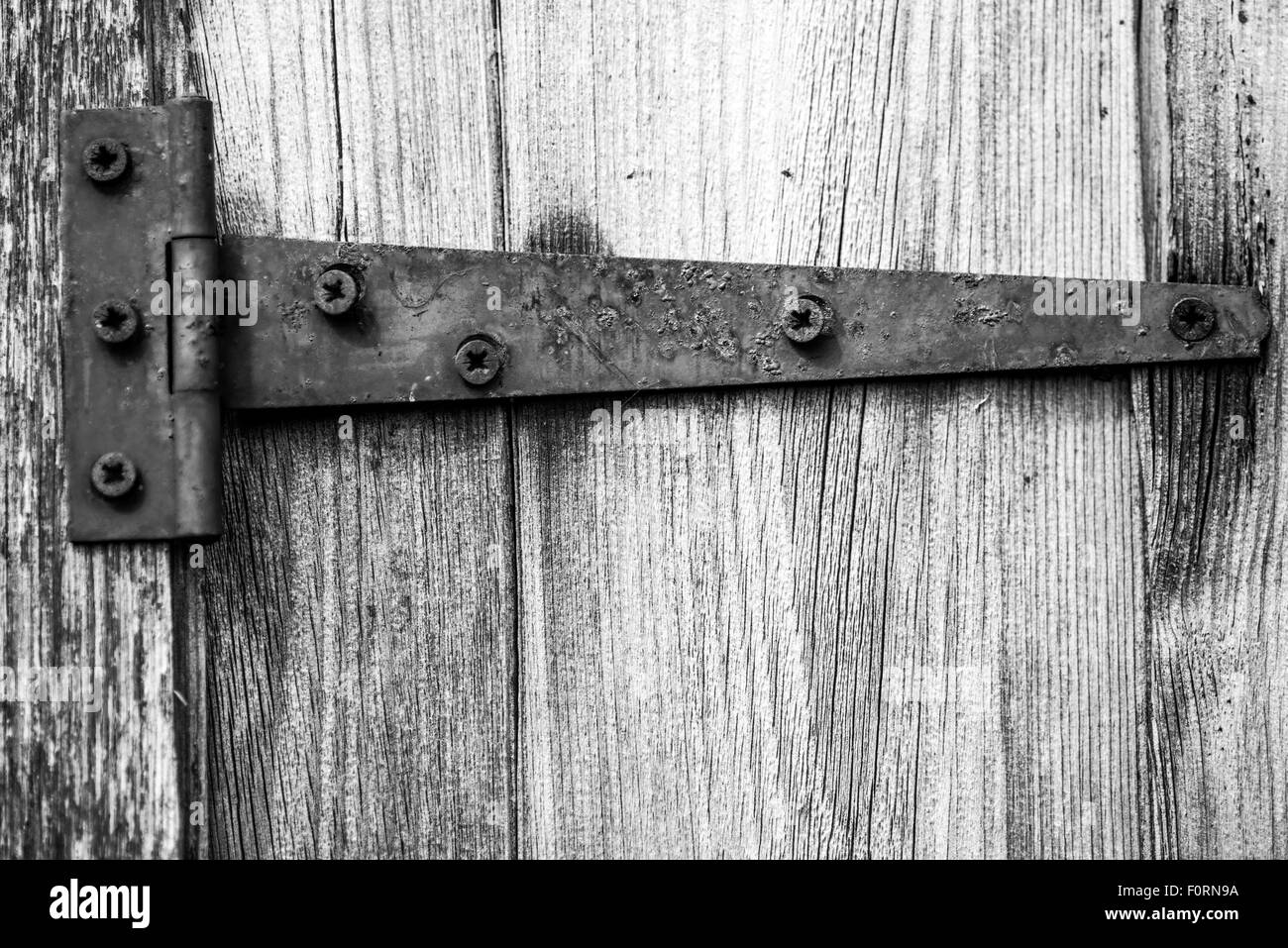 A black and white picture of an old rusty gate hinge Stock Photo - Alamy