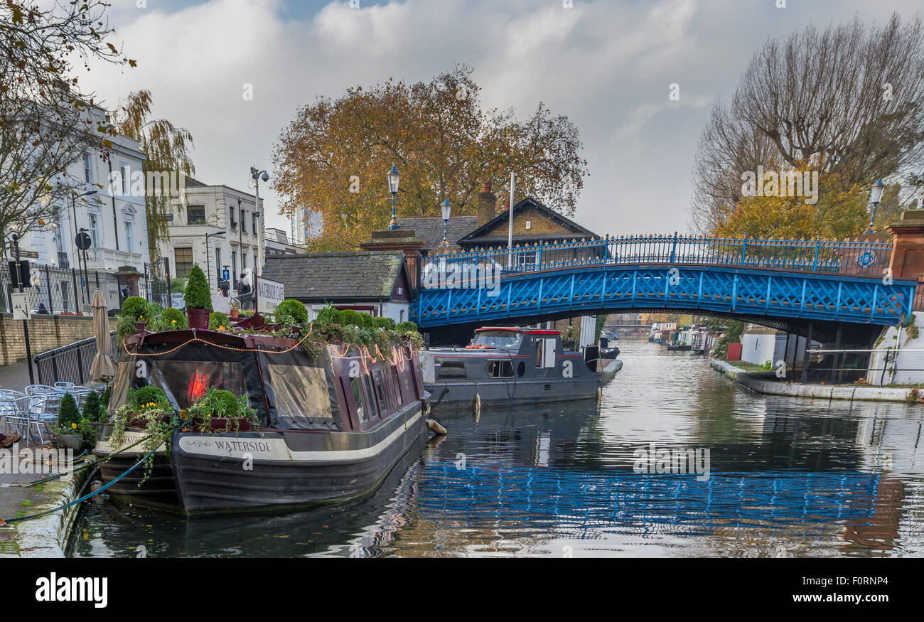 A narrowboat moored on the tow path with a blue bridge over The Regents ...