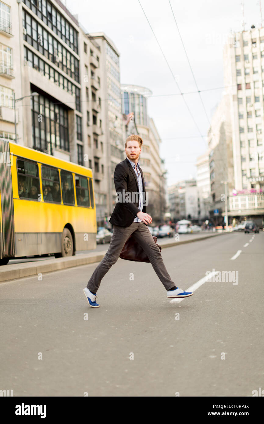 Businessman rushing across the road in a hurry Stock Photo - Alamy