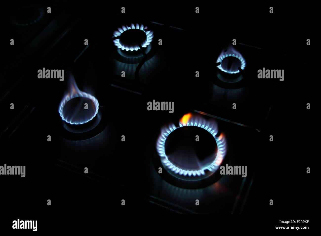 four flame a gas stovel in home cooking Stock Photo - Alamy