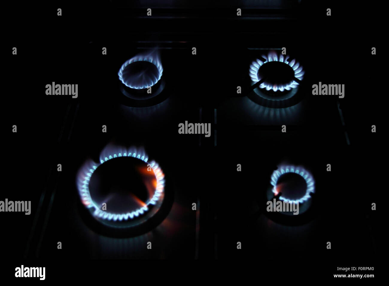 four flame a gas stovel in home cooking Stock Photo - Alamy
