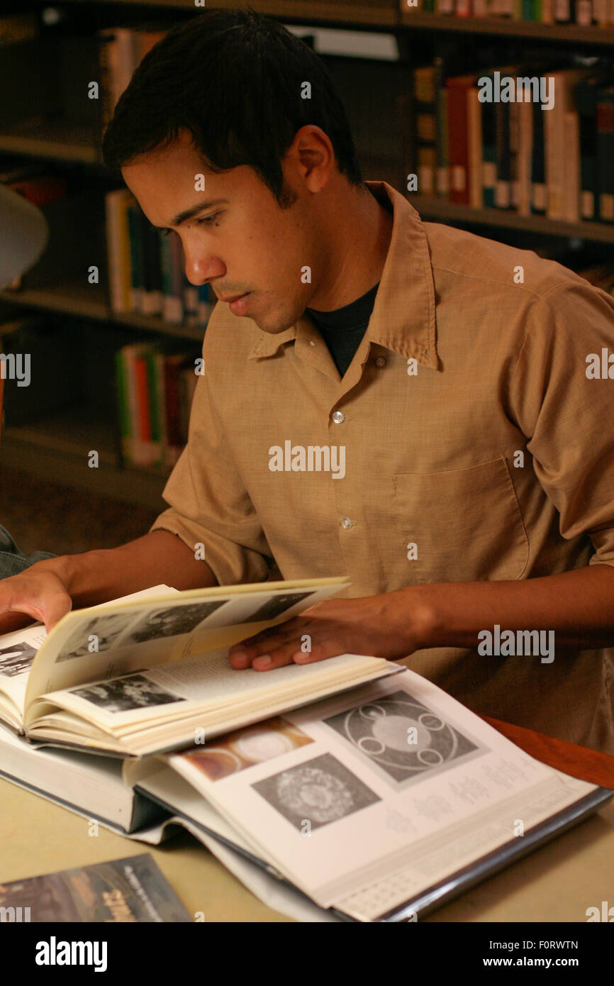 College student reading book flipping through pages Stock Photo - Alamy