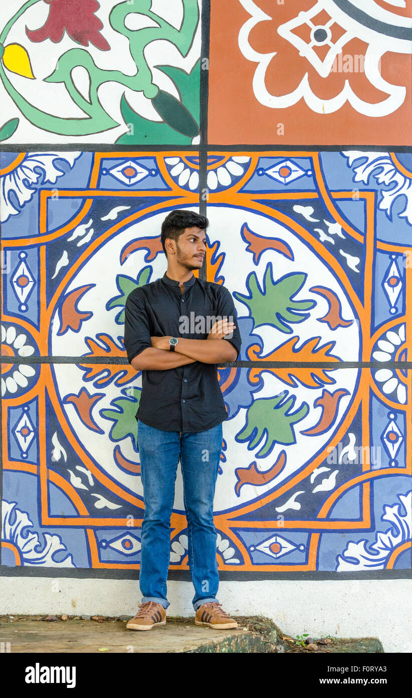 Young man standing in front of colorful tiled modern azulejo wall of ...