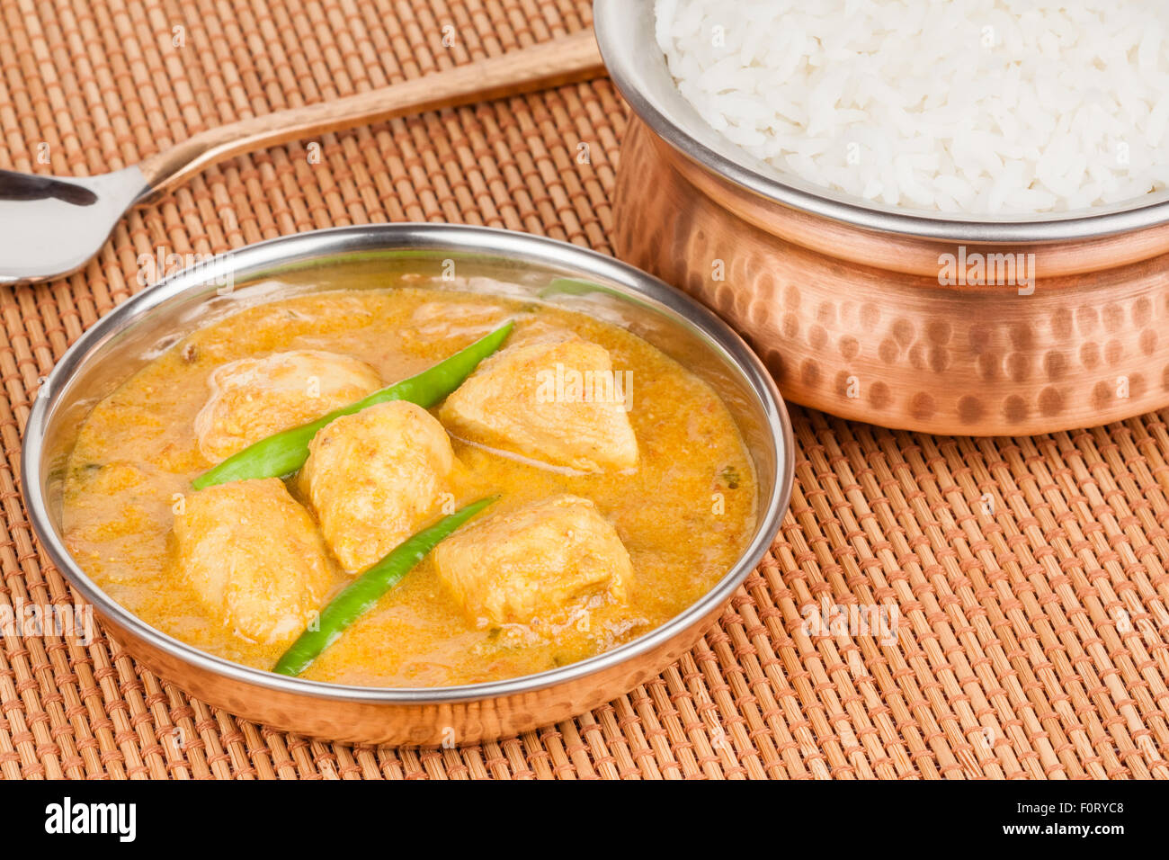 Indian chicken curry served with rice in authentic copper utensils ...