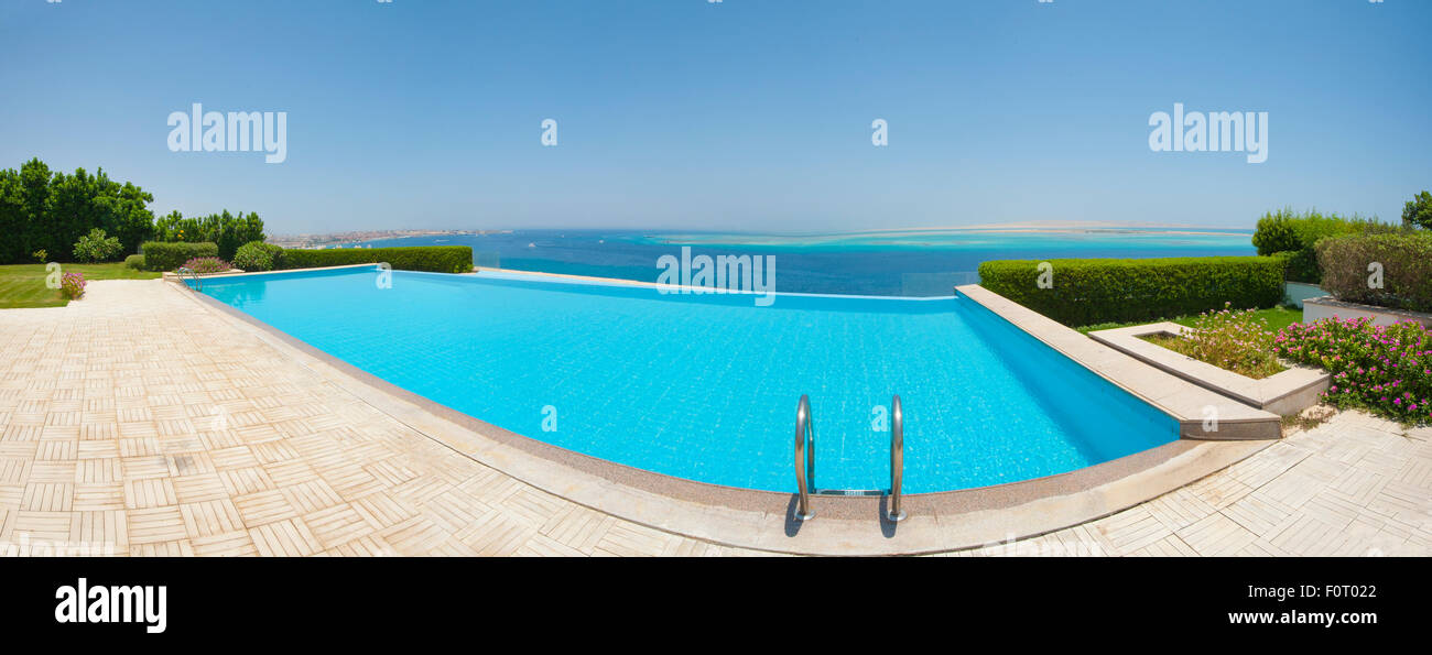 Panoramic view from a luxury infinity swimming pool with tropical sea ...