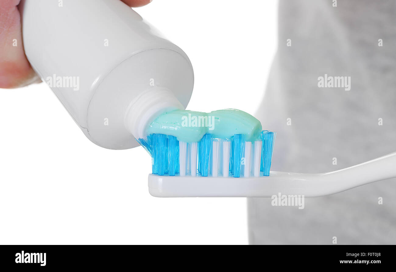 applying Toothpaste to tooth brush isolated over white with copy-space ...
