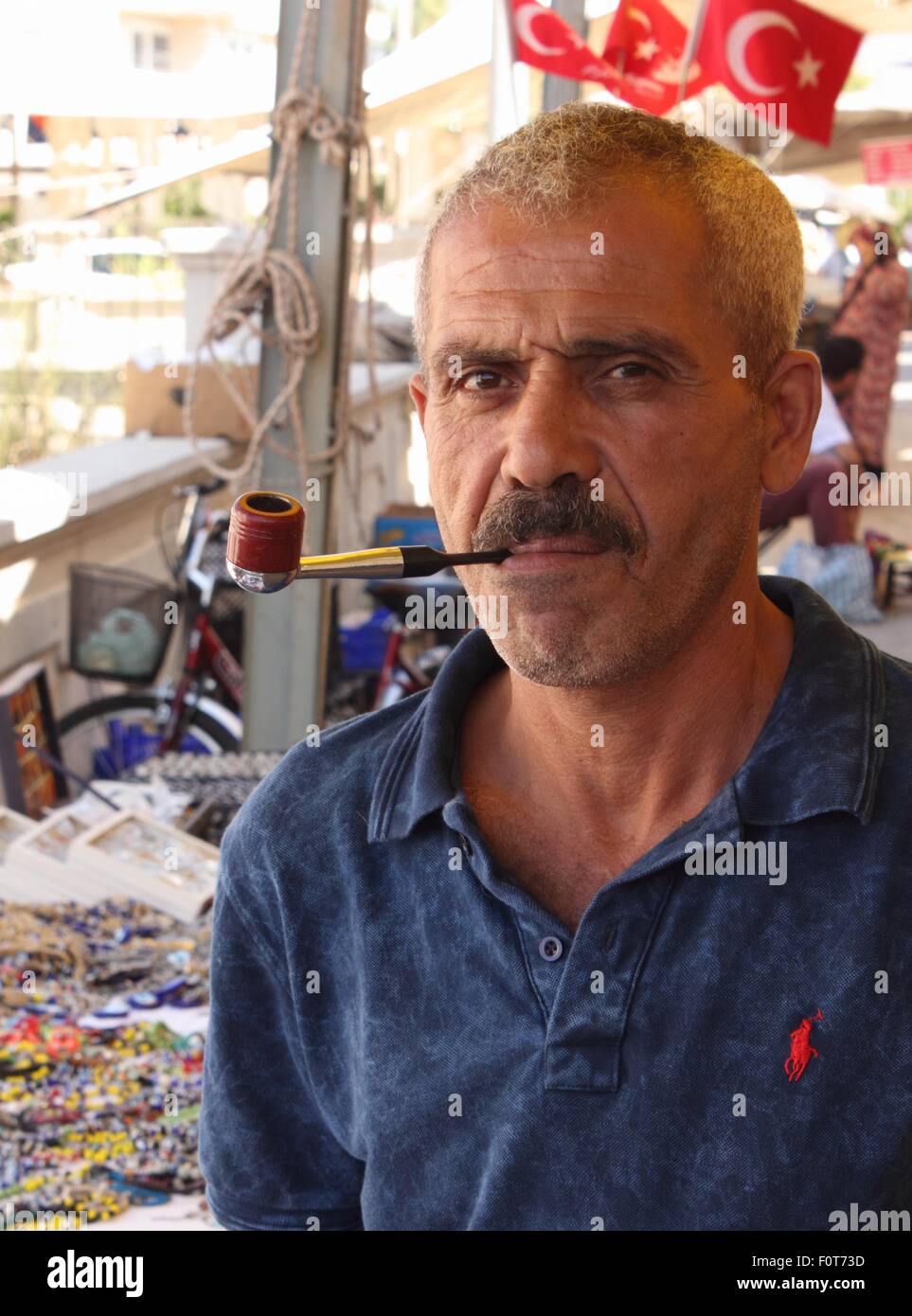 A turkish male smoking a pipe while at a local market in calis in ...