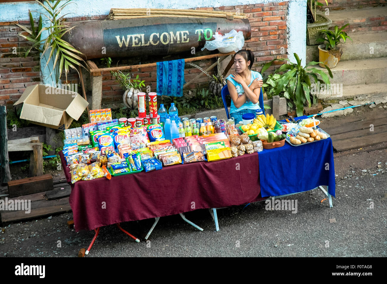 woman selling fruit and cookies at streetshop in village pak beng in ...
