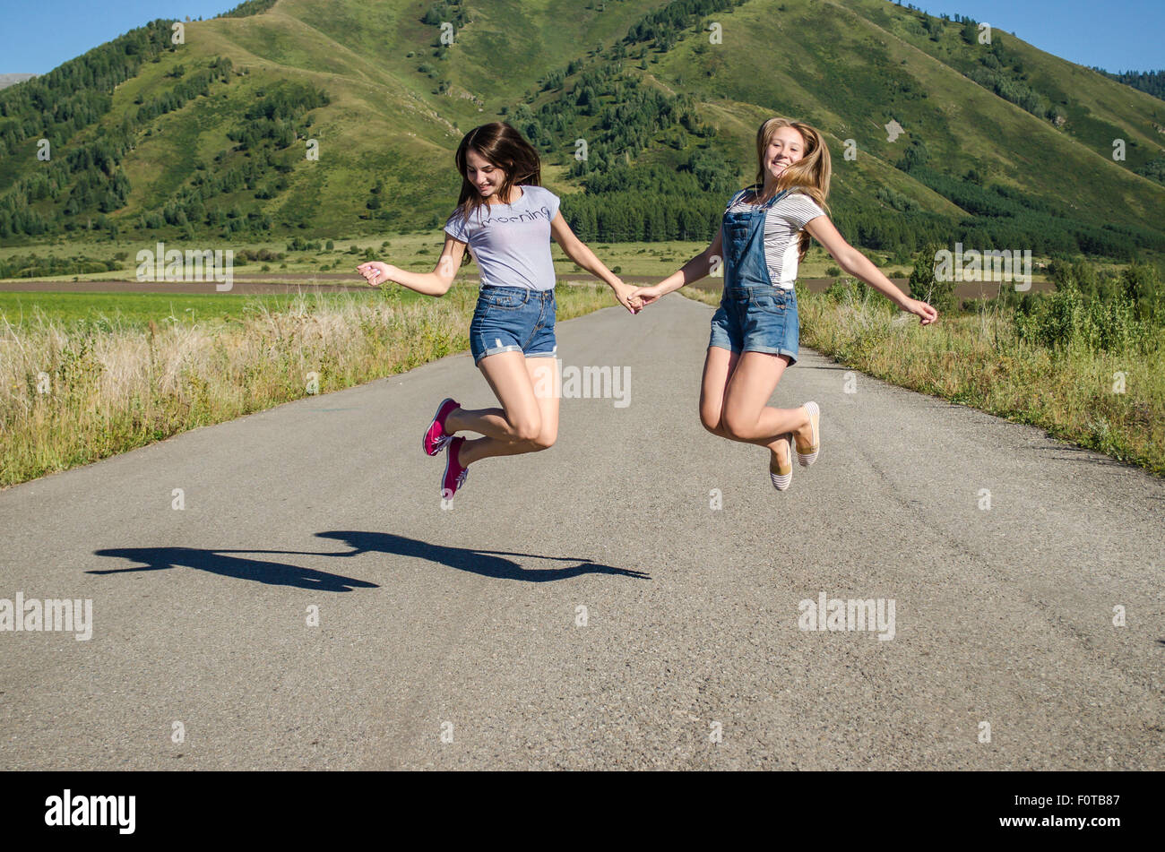 girls jumping on the road Stock Photo - Alamy