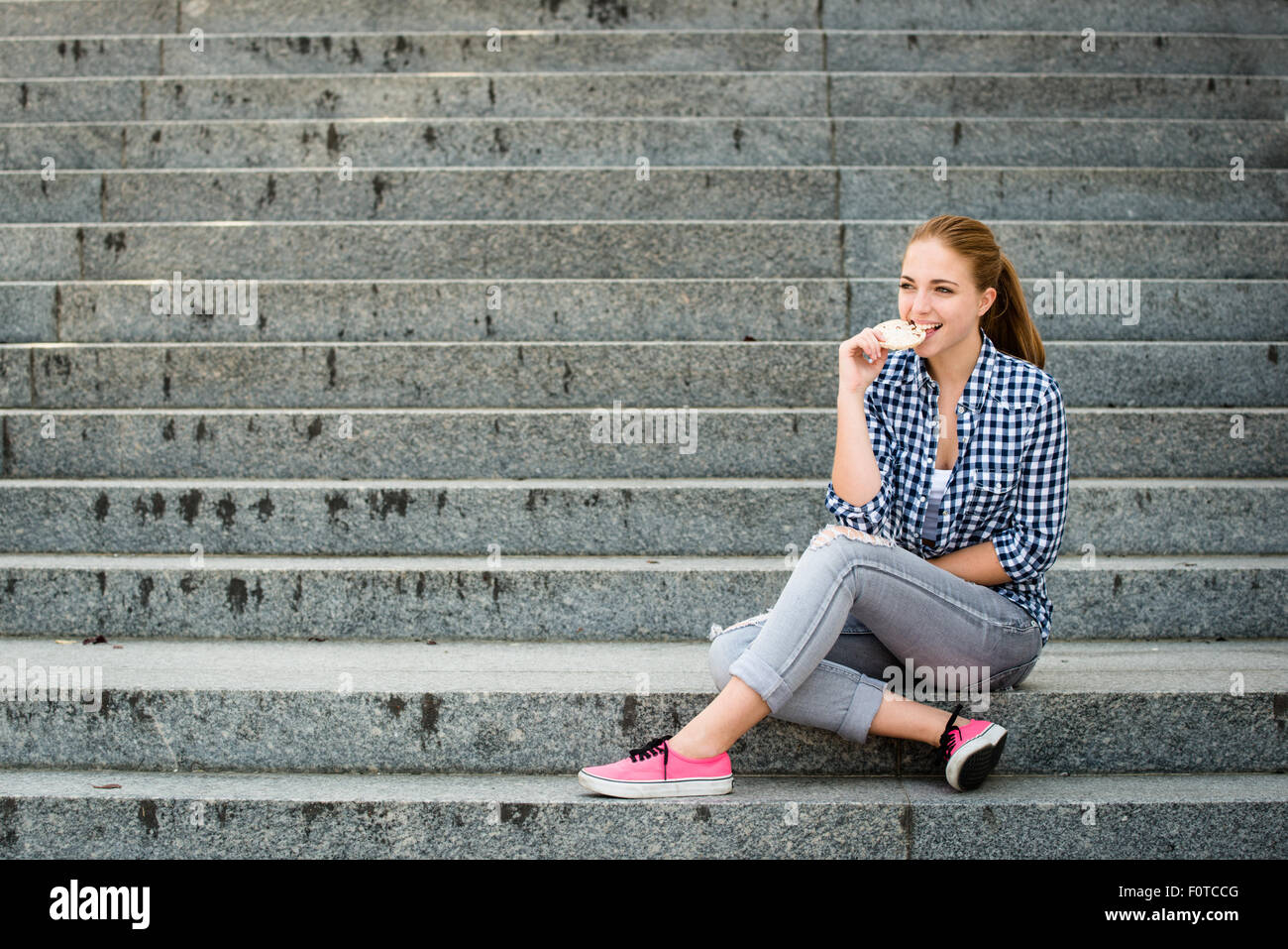 Healthy lifestyle - teenager eating puffed bread outdoor sitting on ...
