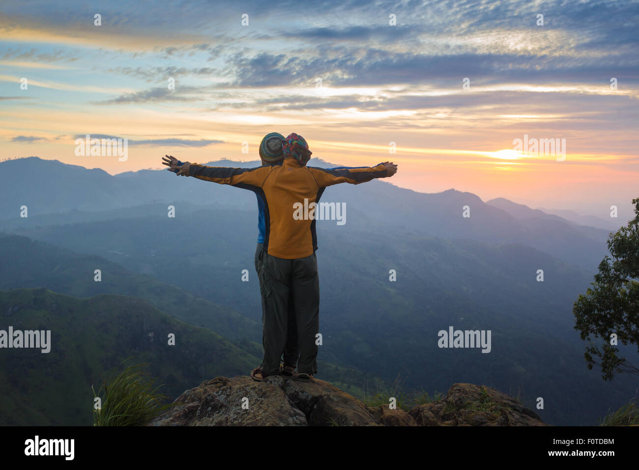 Two tourists with backpacks enjoying sunset on top Stock Photo - Alamy