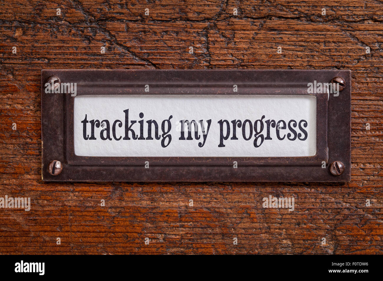 tracking my progress - a label on a grunge wooden file cabinet Stock ...