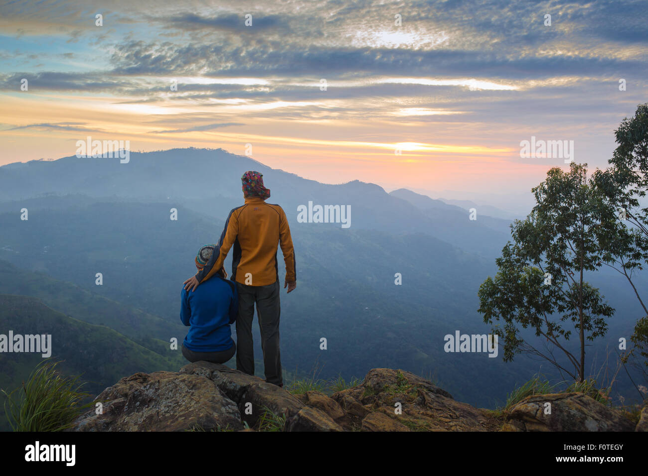 Two tourists with backpacks enjoying sunset on top Stock Photo - Alamy