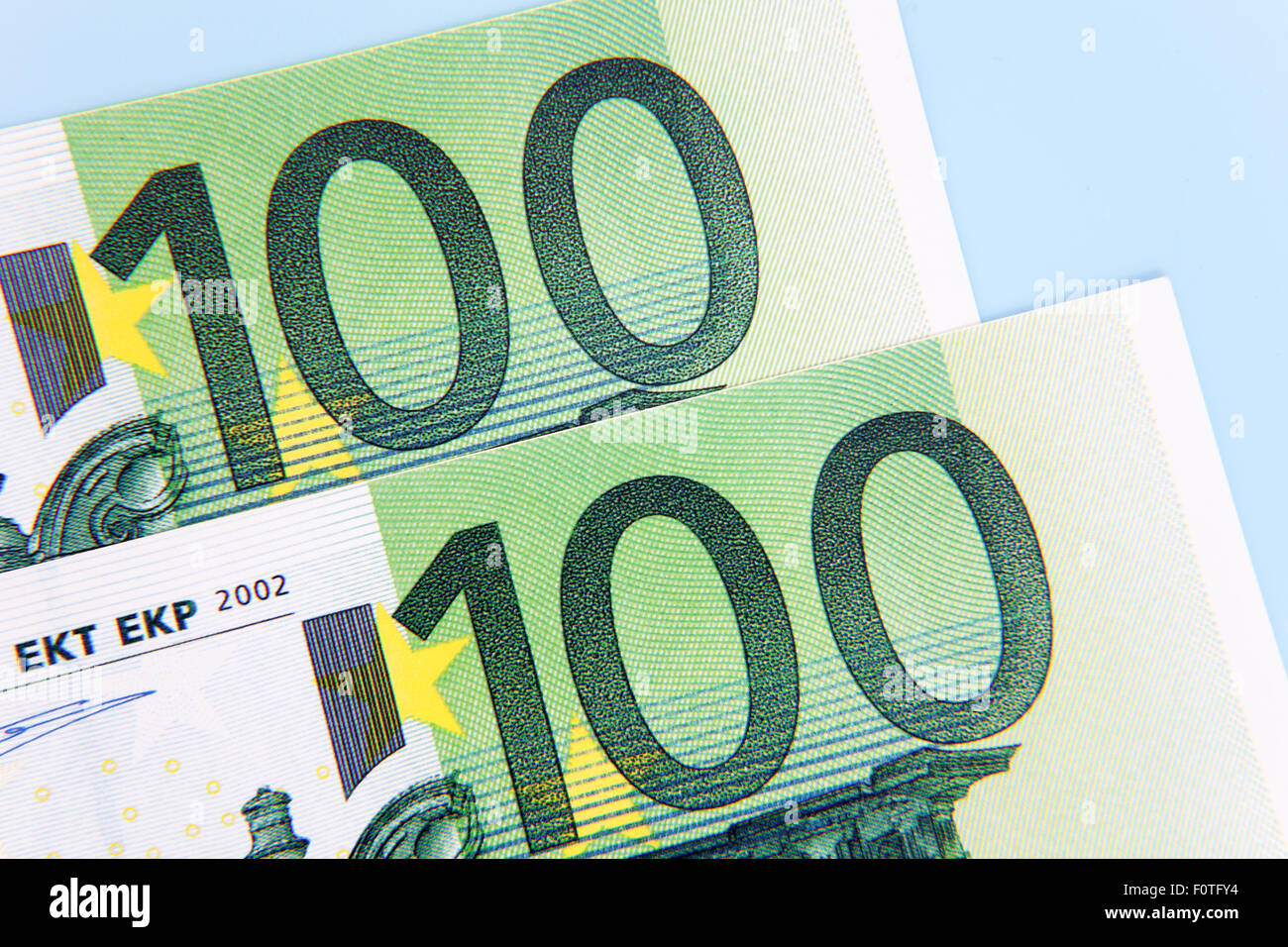 Two 100 euro notes on light blue background Stock Photo - Alamy