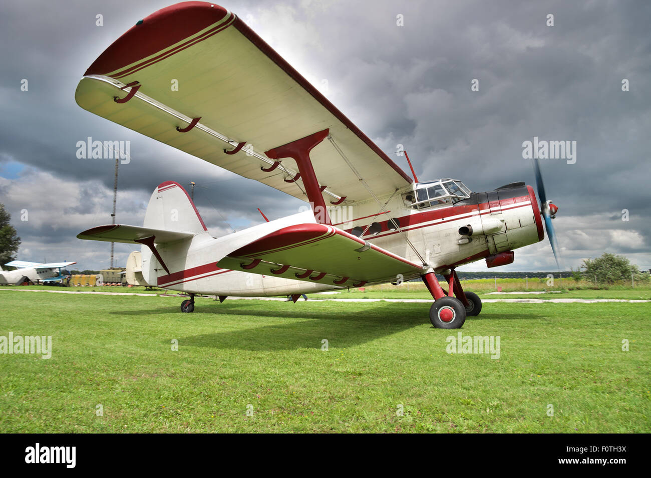 Old biplane preparing for a takeoff from the grass airstrip with ...