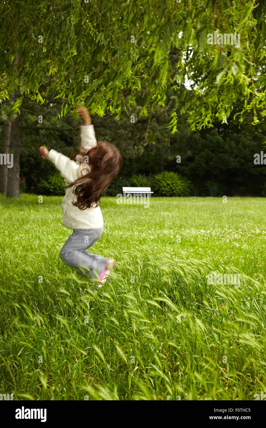 Young girl jumping up to reach a willow Stock Photo - Alamy