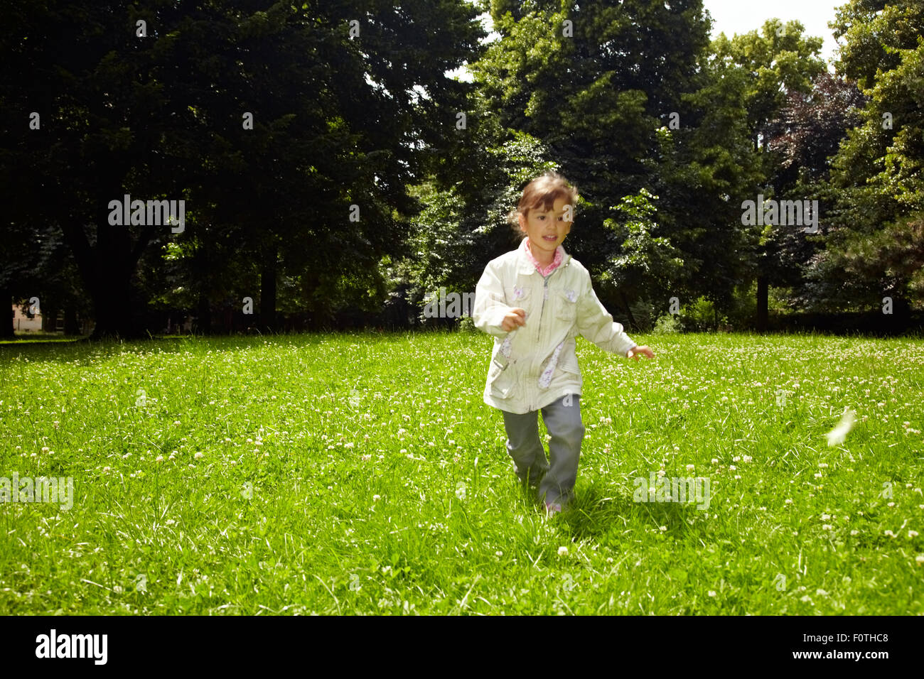 Happy girl running after a white butterfly (motion blur Stock Photo - Alamy