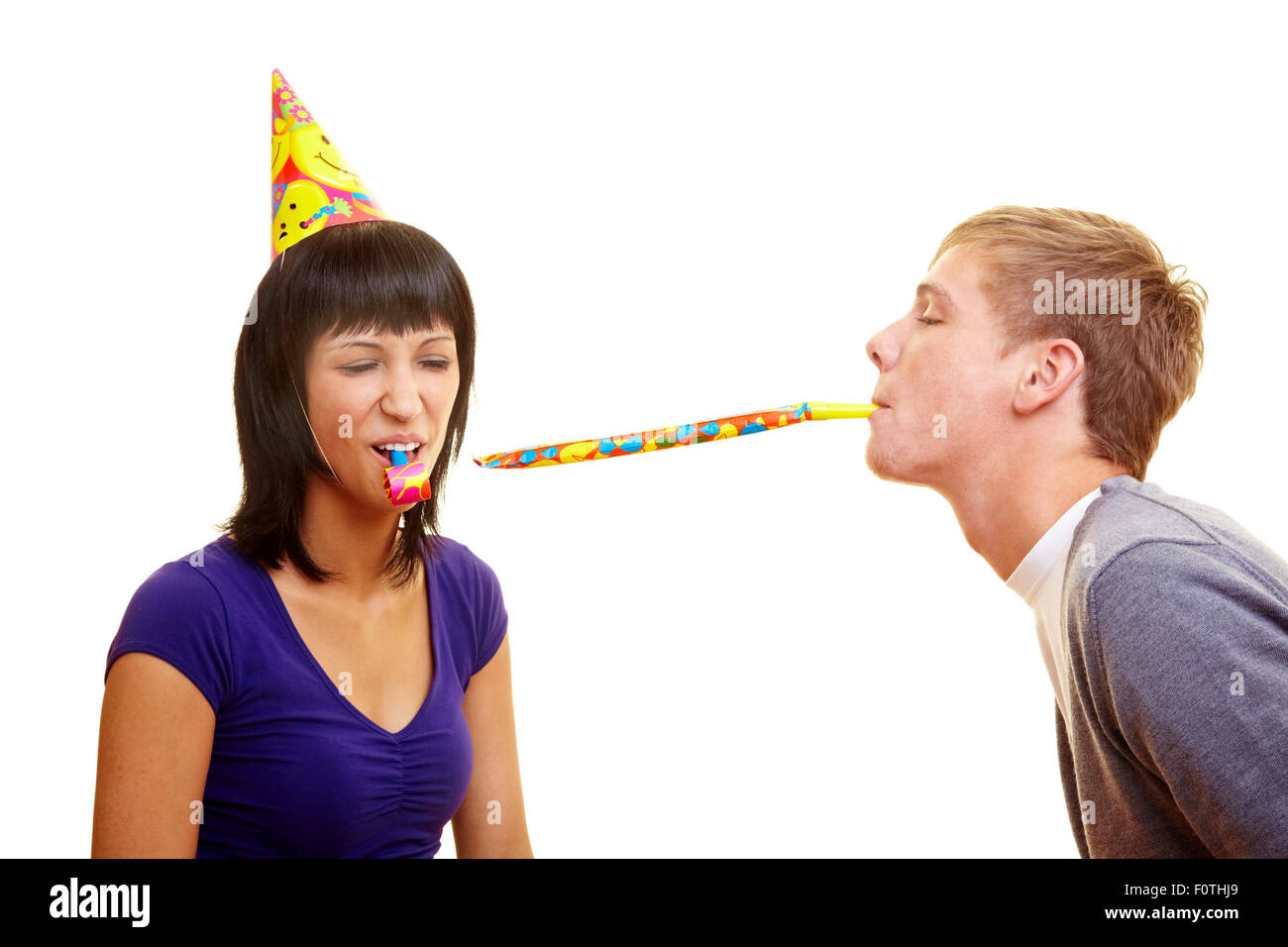 Young couple with party blowers Stock Photo - Alamy