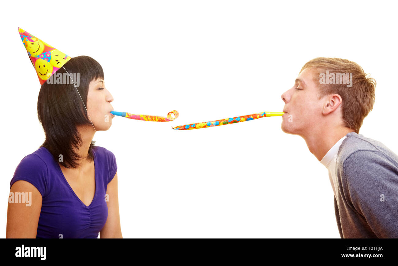 Young couple with party blowers Stock Photo - Alamy