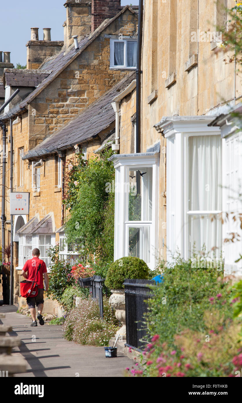 Postman in the Cotswold village of Blockley, Gloucestershire, England ...