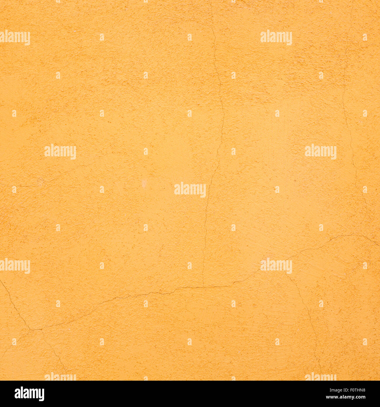 Orange painted wall with stucco render texture and cracks, ideal for a ...