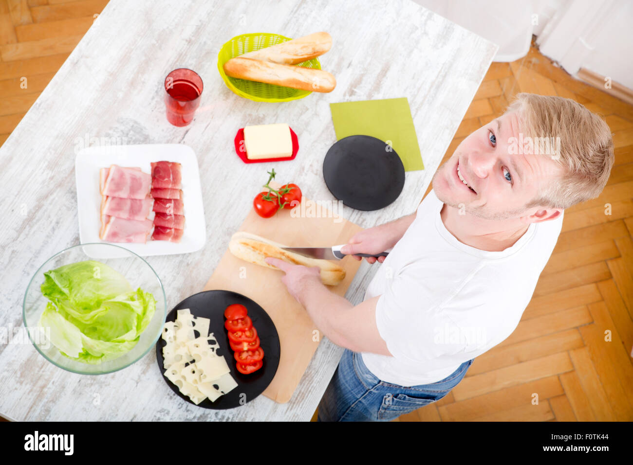 A young man preparing a sandwich in the kitchen Stock Photo - Alamy