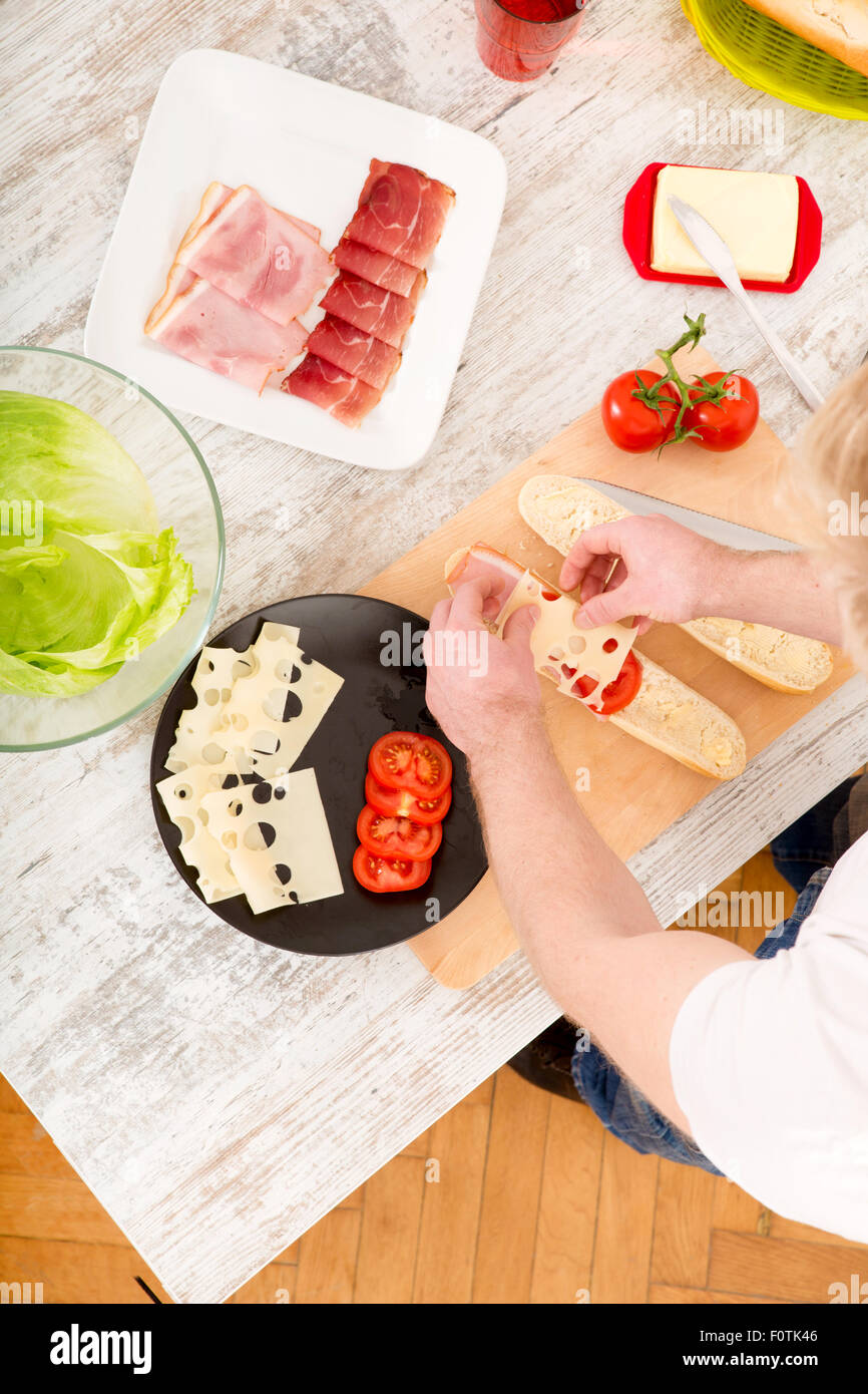 A young man preparing a sandwich in the kitchen Stock Photo - Alamy
