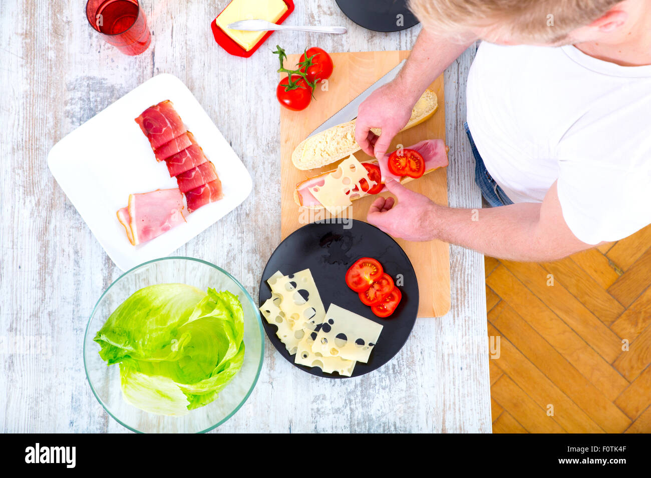 A young man preparing a sandwich in the kitchen Stock Photo - Alamy