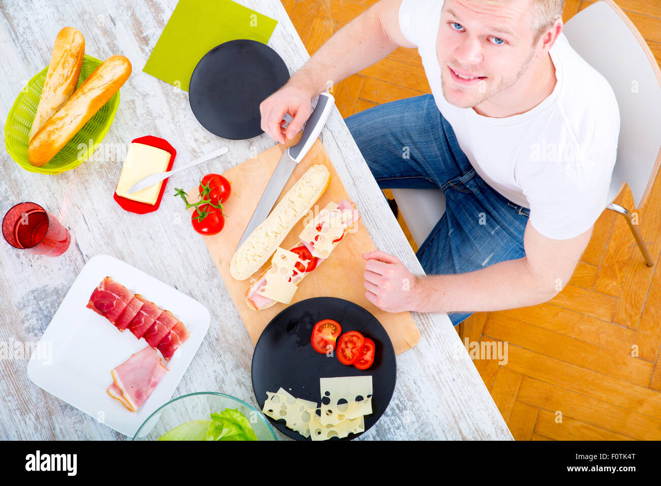 A young man preparing a sandwich in the kitchen Stock Photo - Alamy
