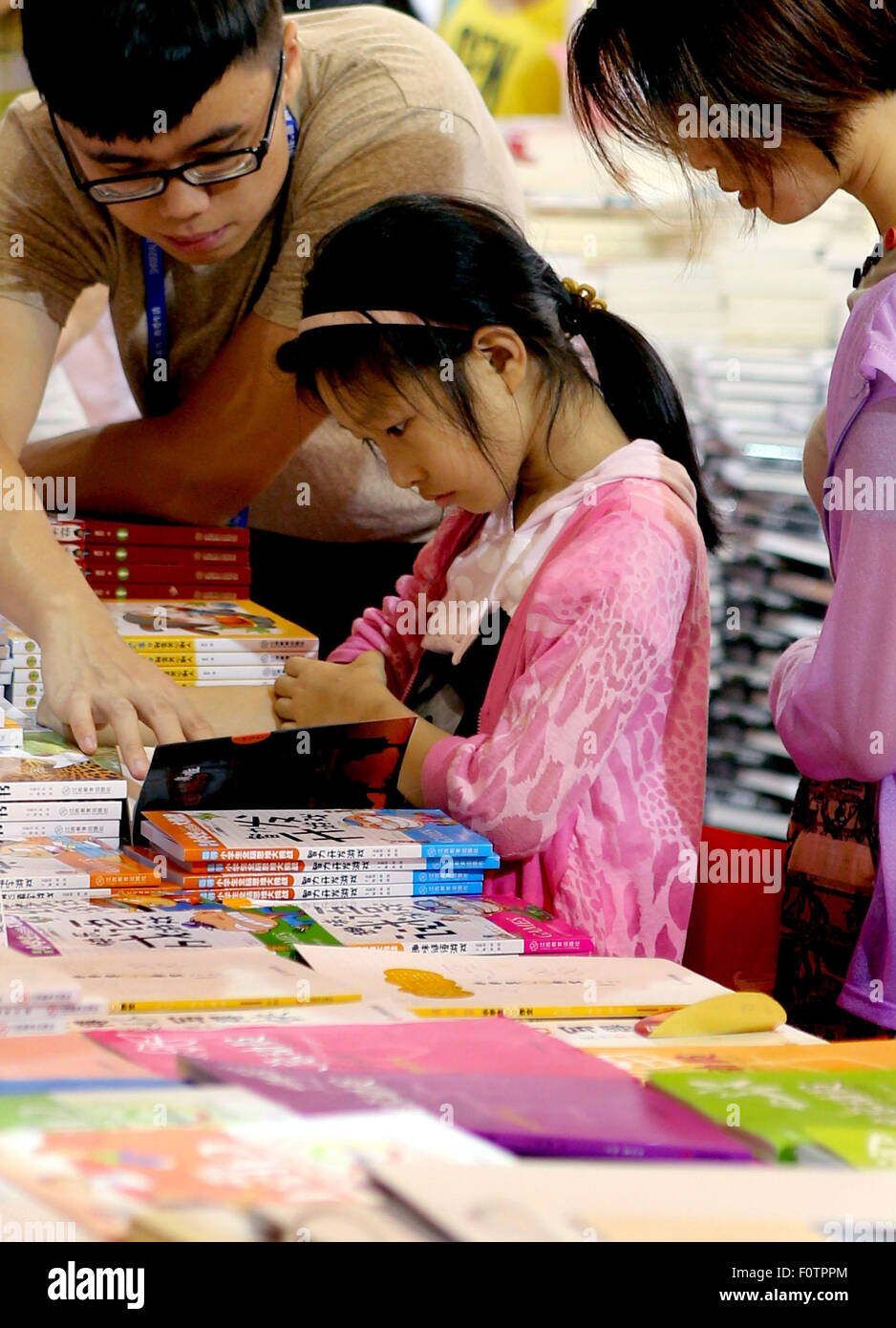 Shanghai, China. 21st Aug, 2015. A girl reads books at the 2015 ...