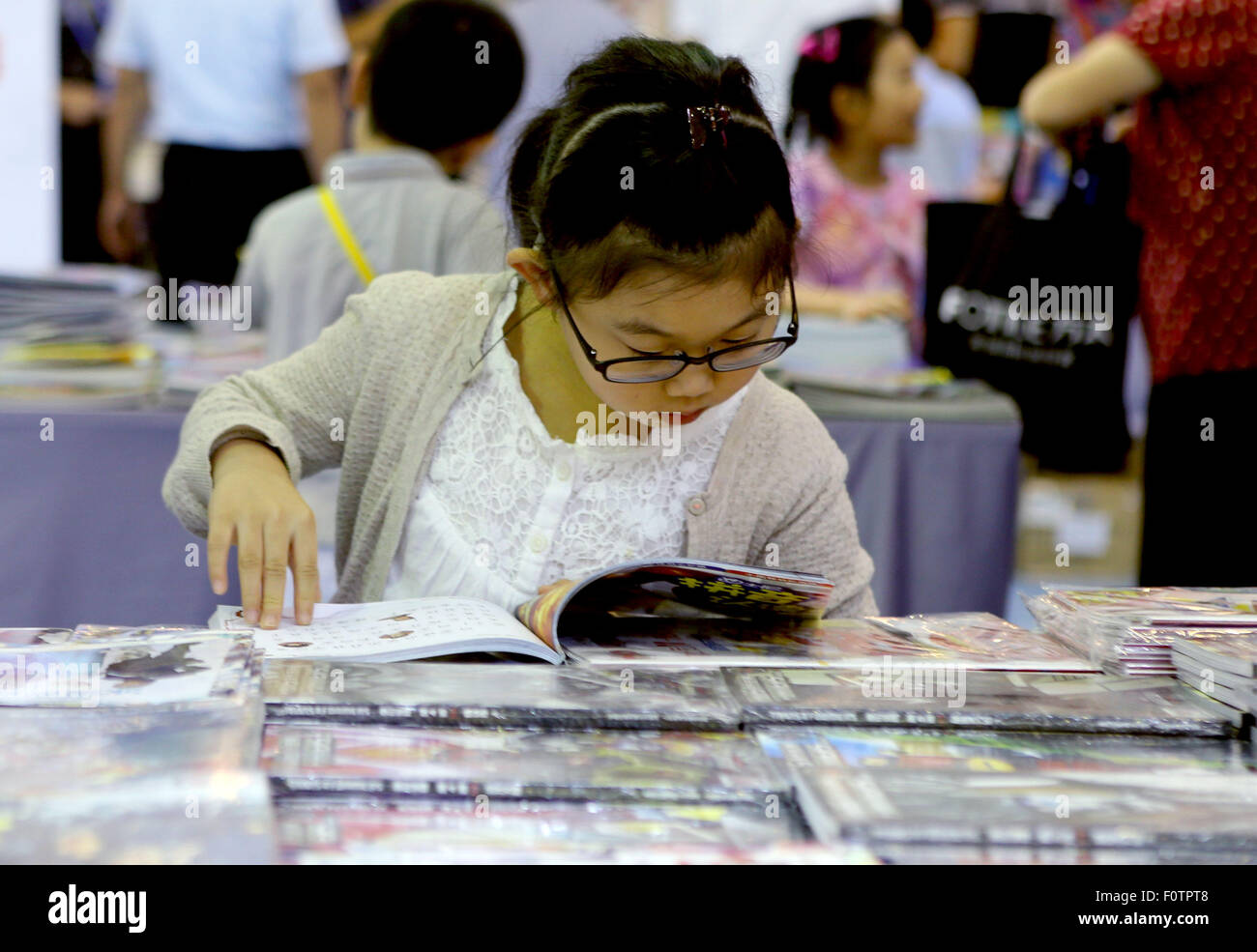 Shanghai, China. 21st Aug, 2015. A girl reads books at the 2015 ...