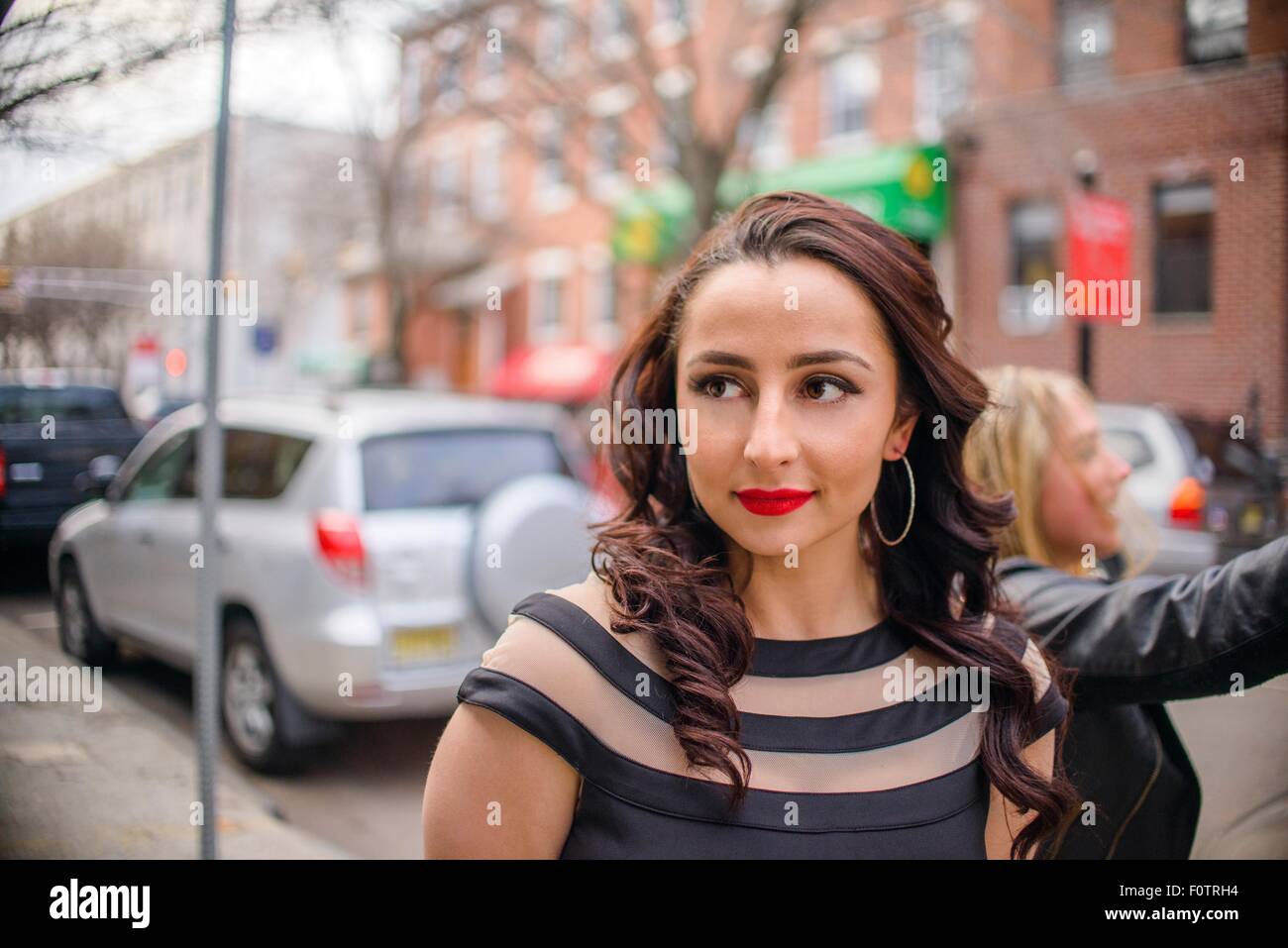 Glamorous young woman walking along street Stock Photo - Alamy