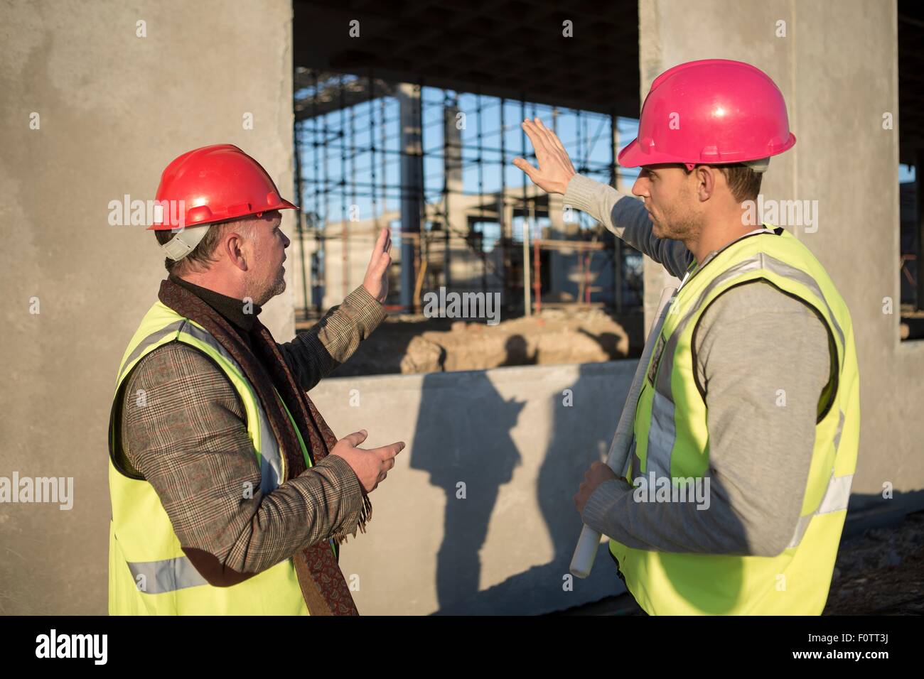 Architect and builder discussing window frame on construction site ...