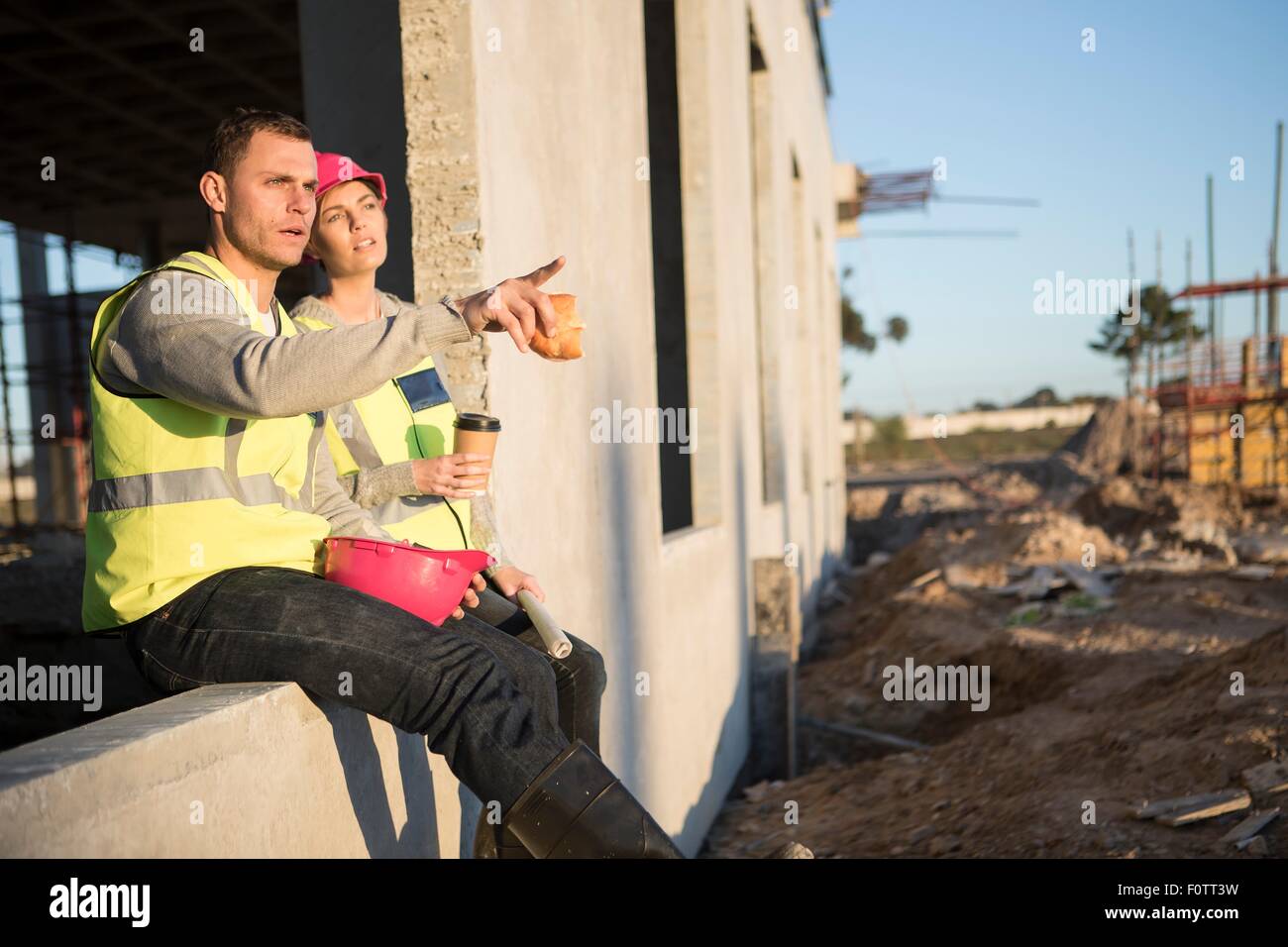 Builder and architect pointing and looking out from window frame on ...