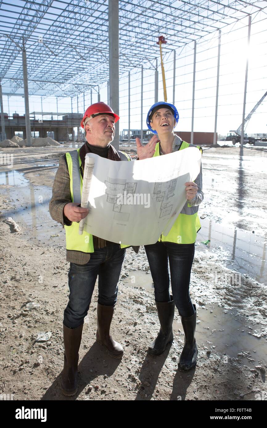 Architect and builder looking up on construction site Stock Photo - Alamy