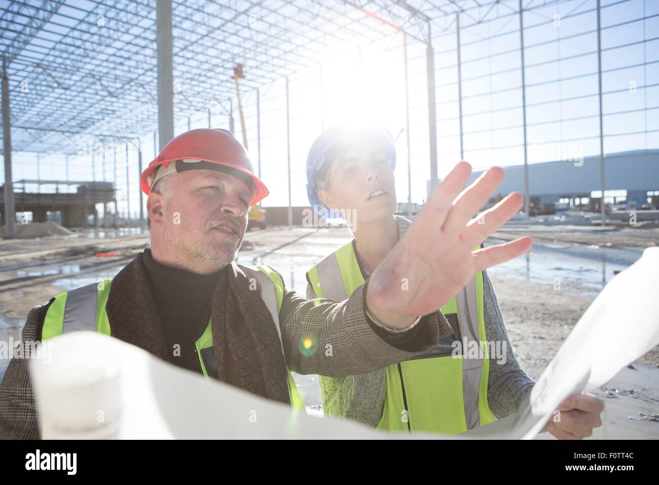 Architect explaining to builder on construction site Stock Photo - Alamy