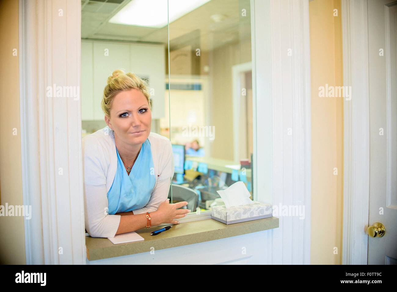 Portrait of female orthodontist at dentist reception hatch Stock Photo ...