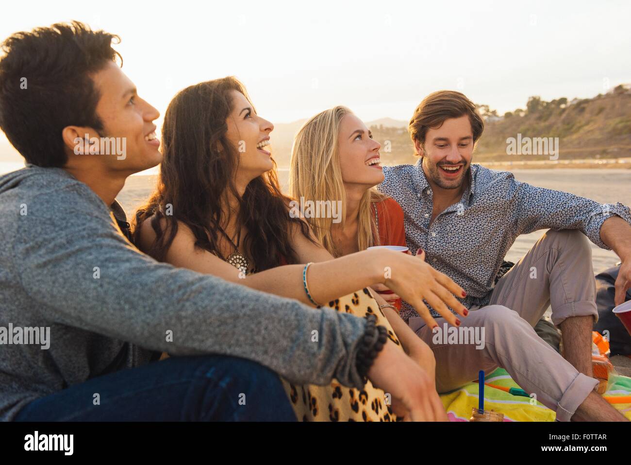 Group of friends sitting together on beach Stock Photo - Alamy