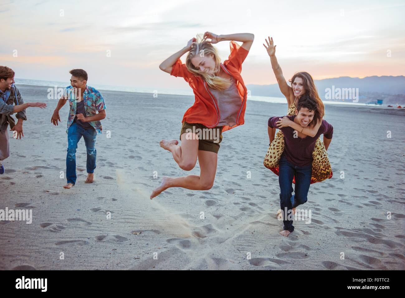 Group of friends fooling around on beach Stock Photo - Alamy