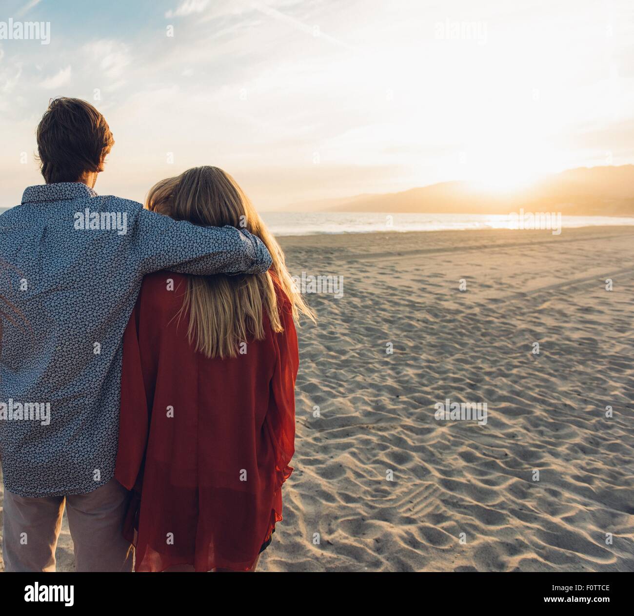 Young couple standing on beach, hugging, rear view Stock Photo - Alamy