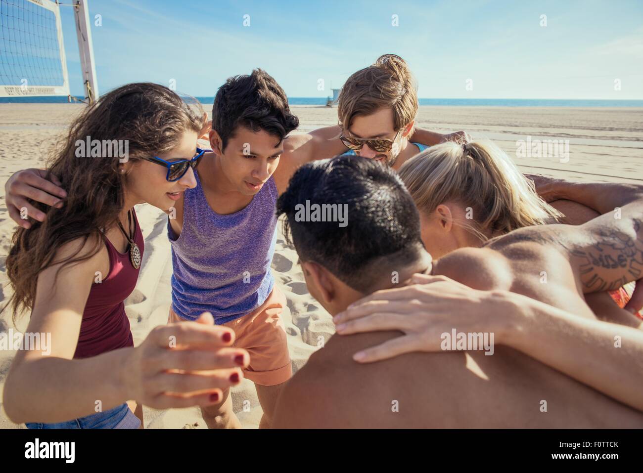 Group of friends in huddle on beach Stock Photo - Alamy