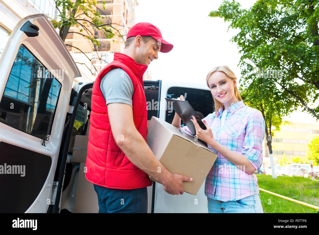 First class delivery service. Courier Delivering Package By Van Stock ...