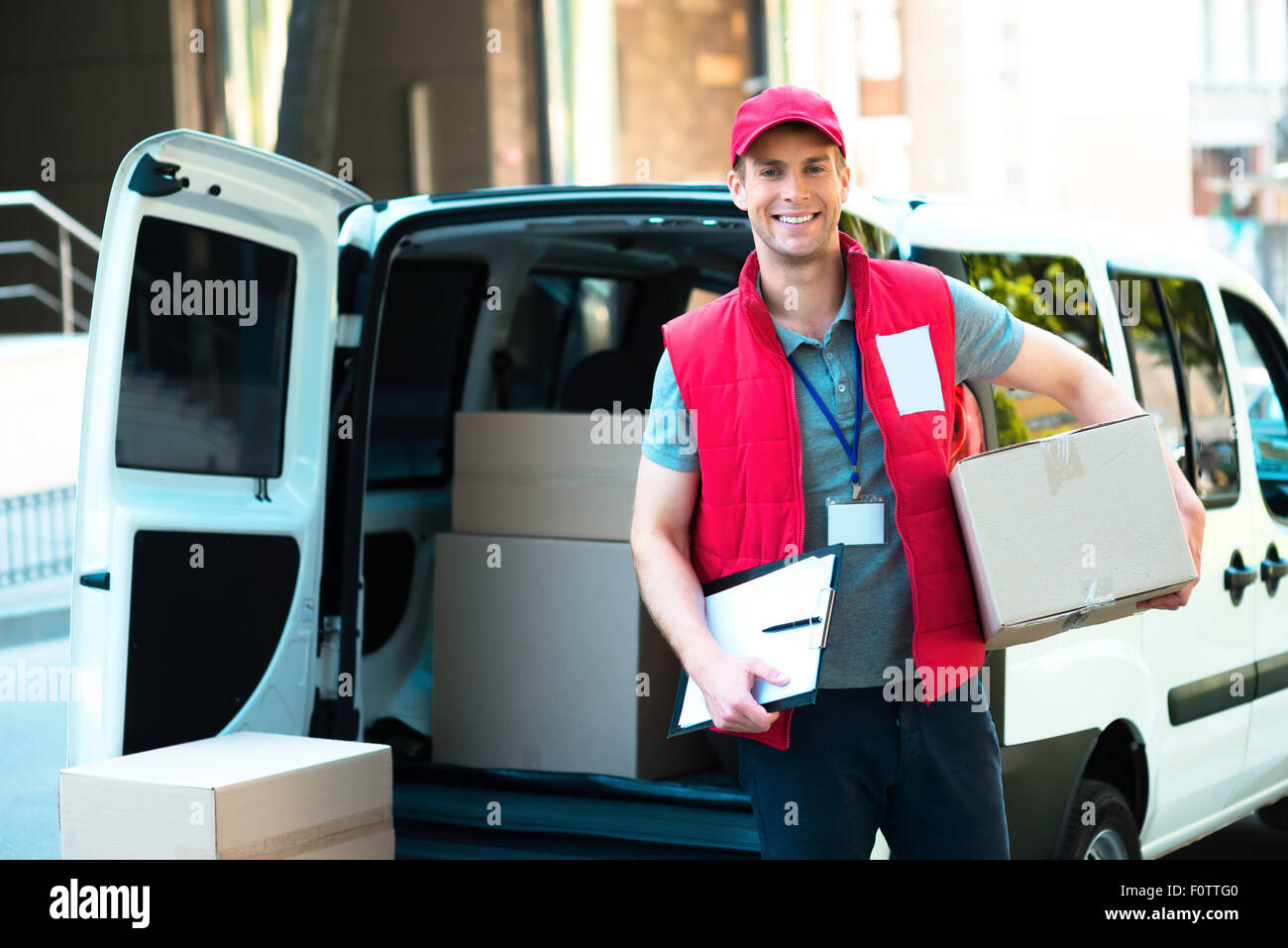 Courier Delivering Package By Van Stock Photo - Alamy